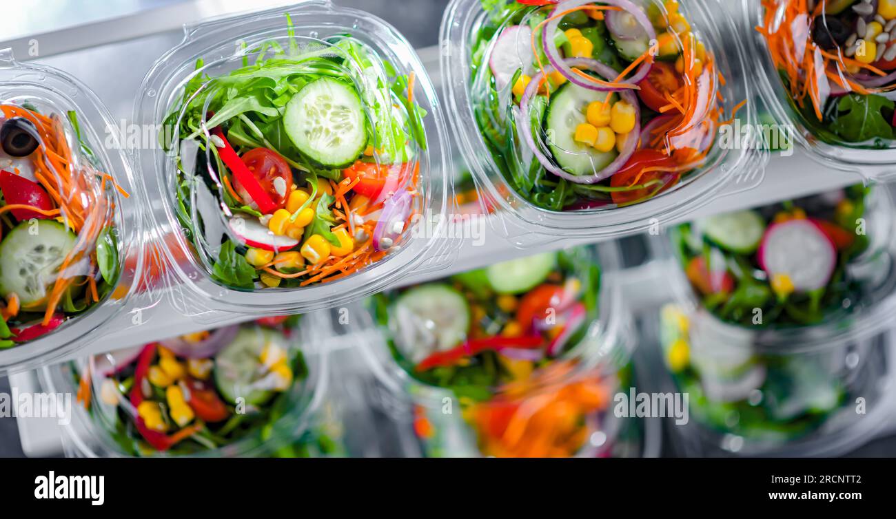 Plastic boxes with pre-packaged vegetable salads, put up for sale in a ...