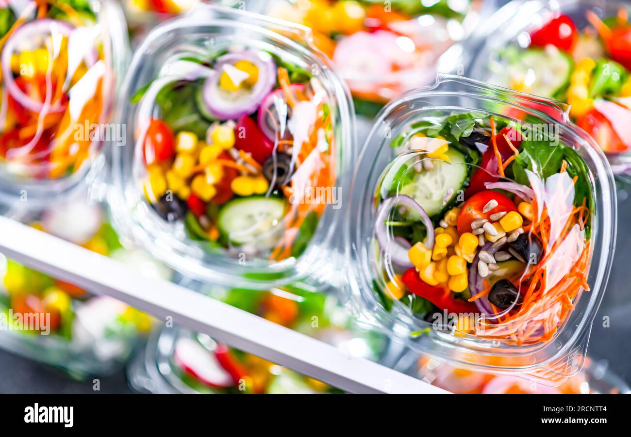 Plastic boxes with pre-packaged vegetable salads, put up for sale in a ...