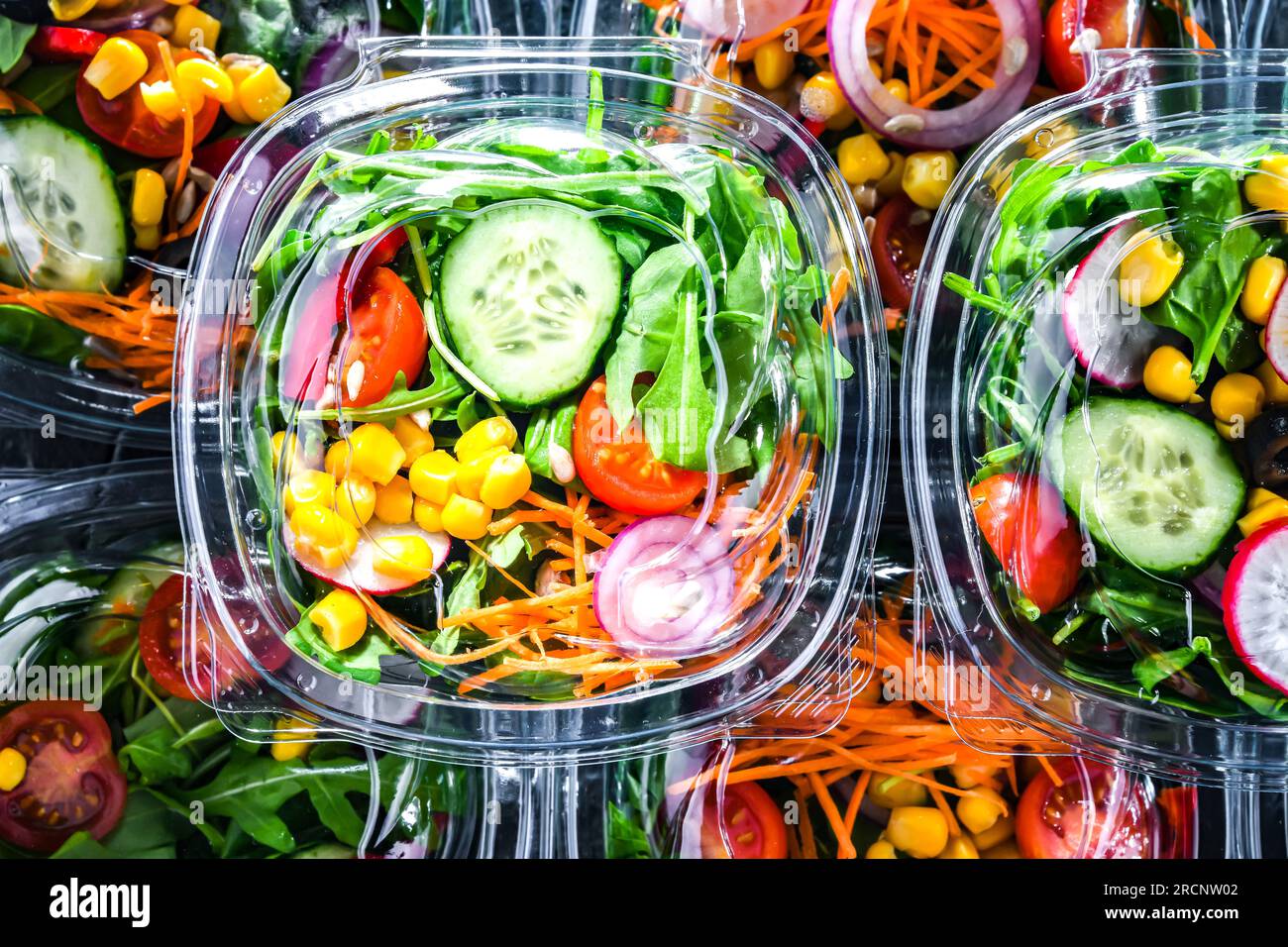 Plastic boxes with pre-packaged vegetable salads, put up for sale in a ...