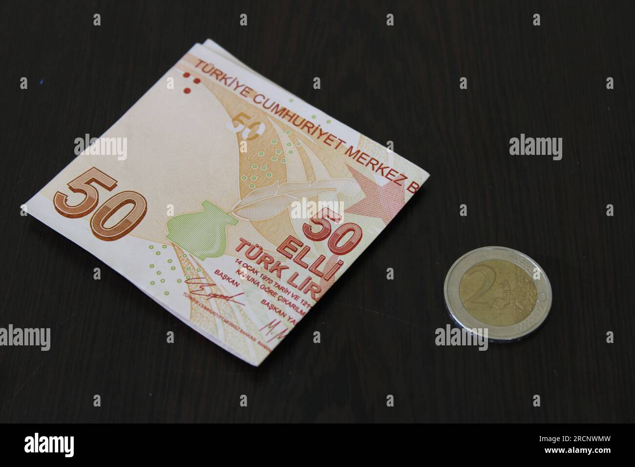 50 Turkish lira and 2 euro on black background. The worthlessness of ...