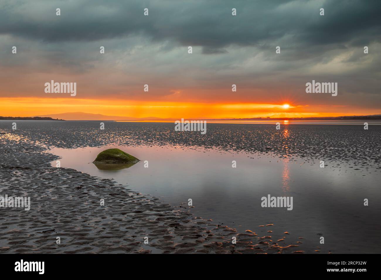 Moody dramatic skies and sunset reflections over Bowness on Solway ...