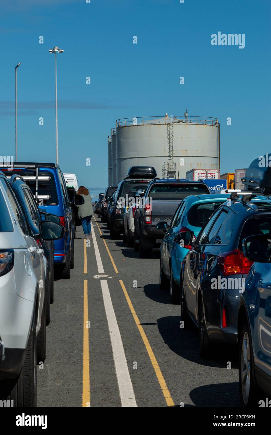Two queues of cars waiting on either side of white and yellow lines ...