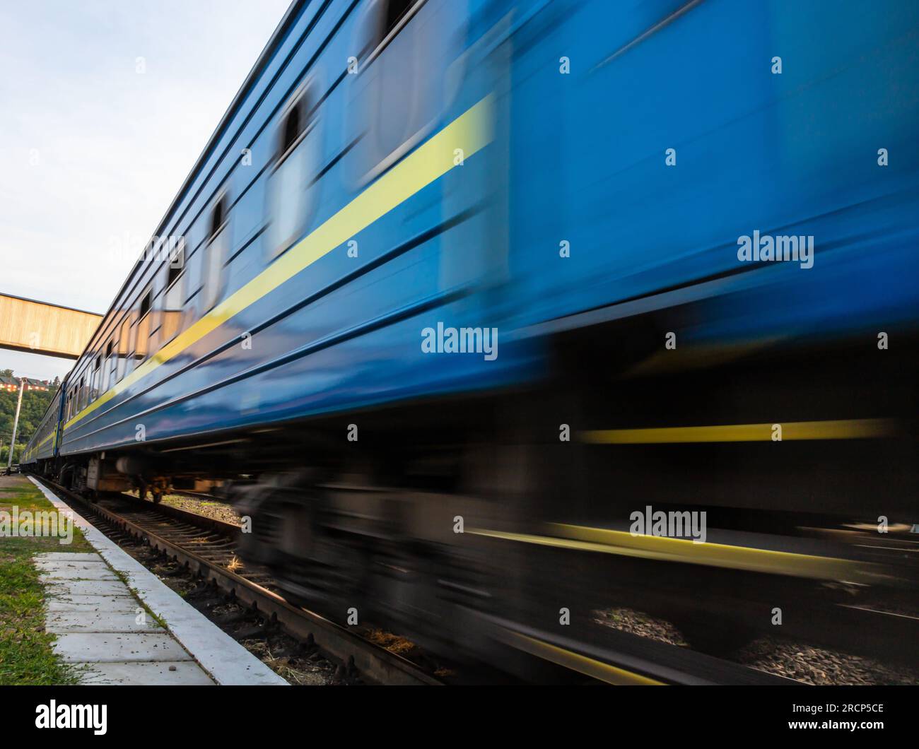 a blue passenger train travels along the track Stock Photo - Alamy