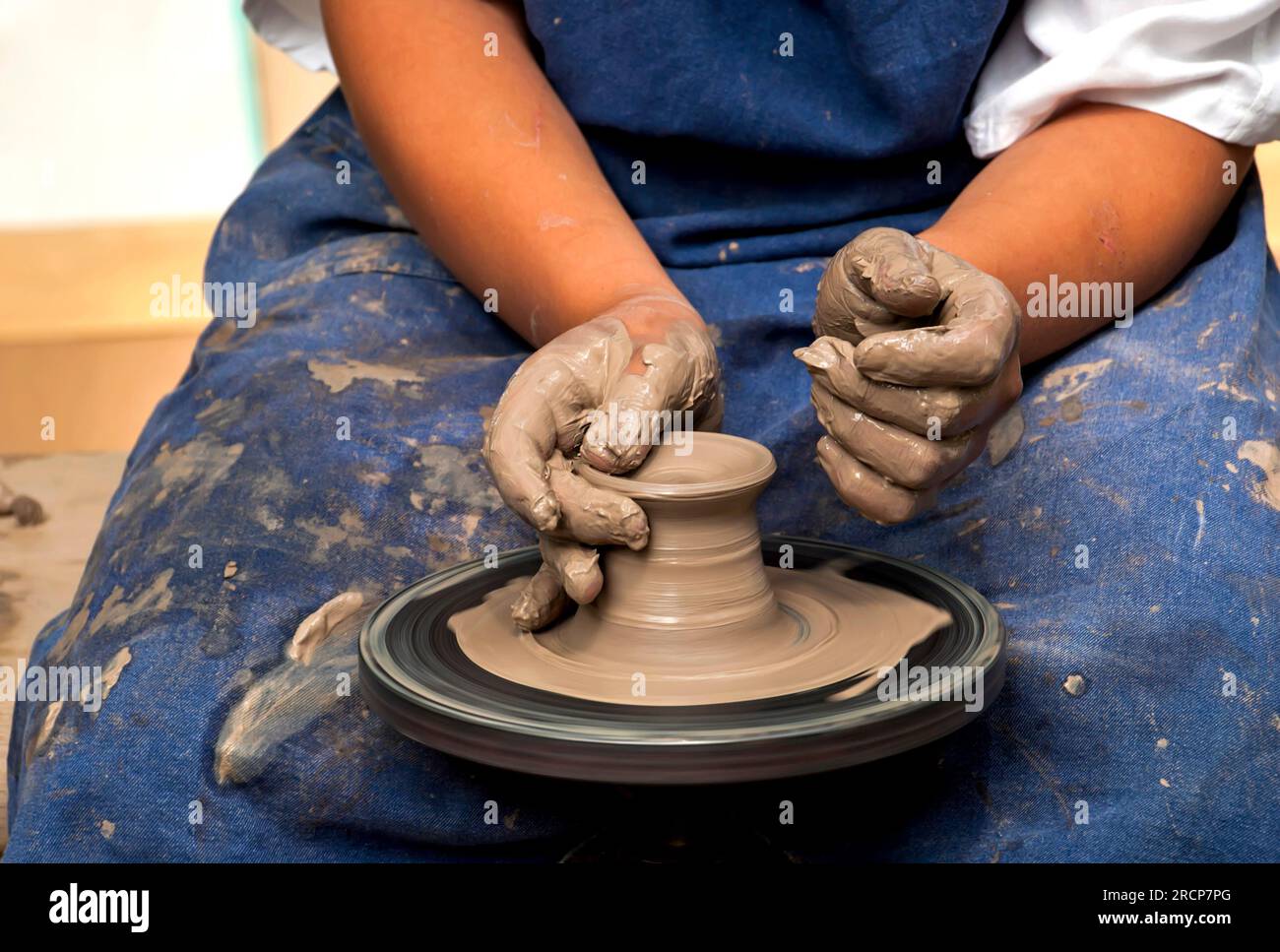 Wet male potter's hands sculpting soft clay and shaping the pot on ...