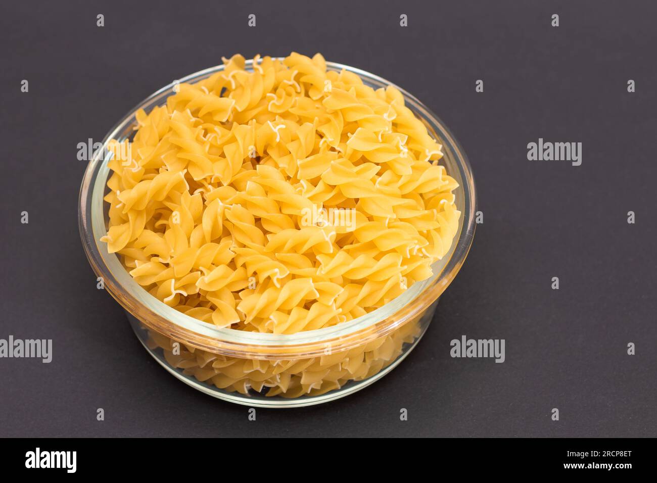 Uncooked Fusilli Pasta in Glass Jar on Black Background. Fat and ...