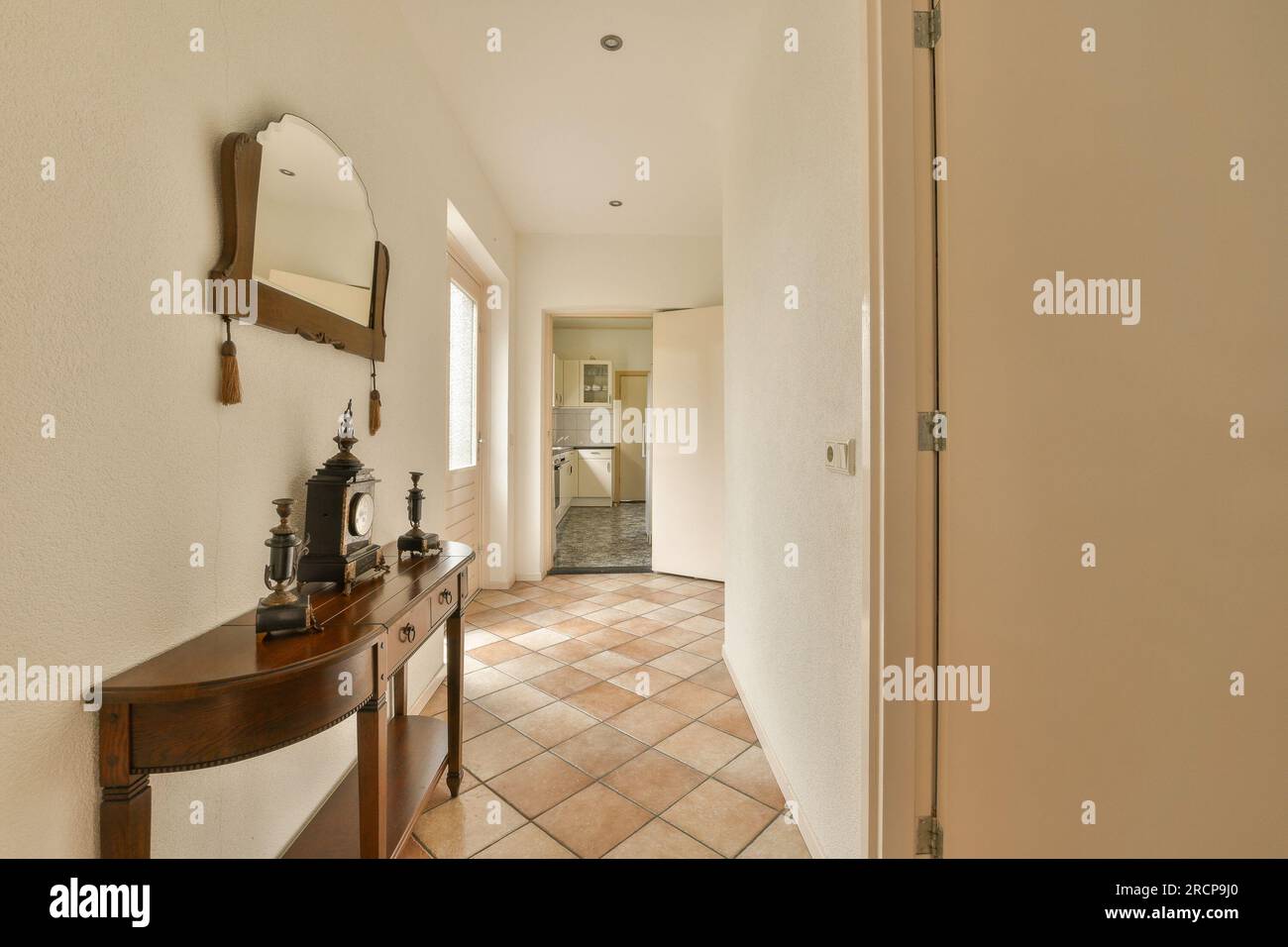 a hallway with a mirror on the wall and an open door leading to another ...