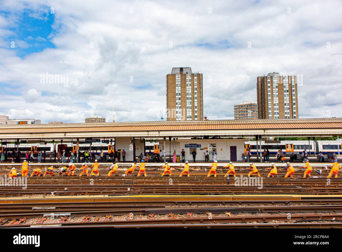 A long line of railway workers pulling a rope at Clapham Junction ...