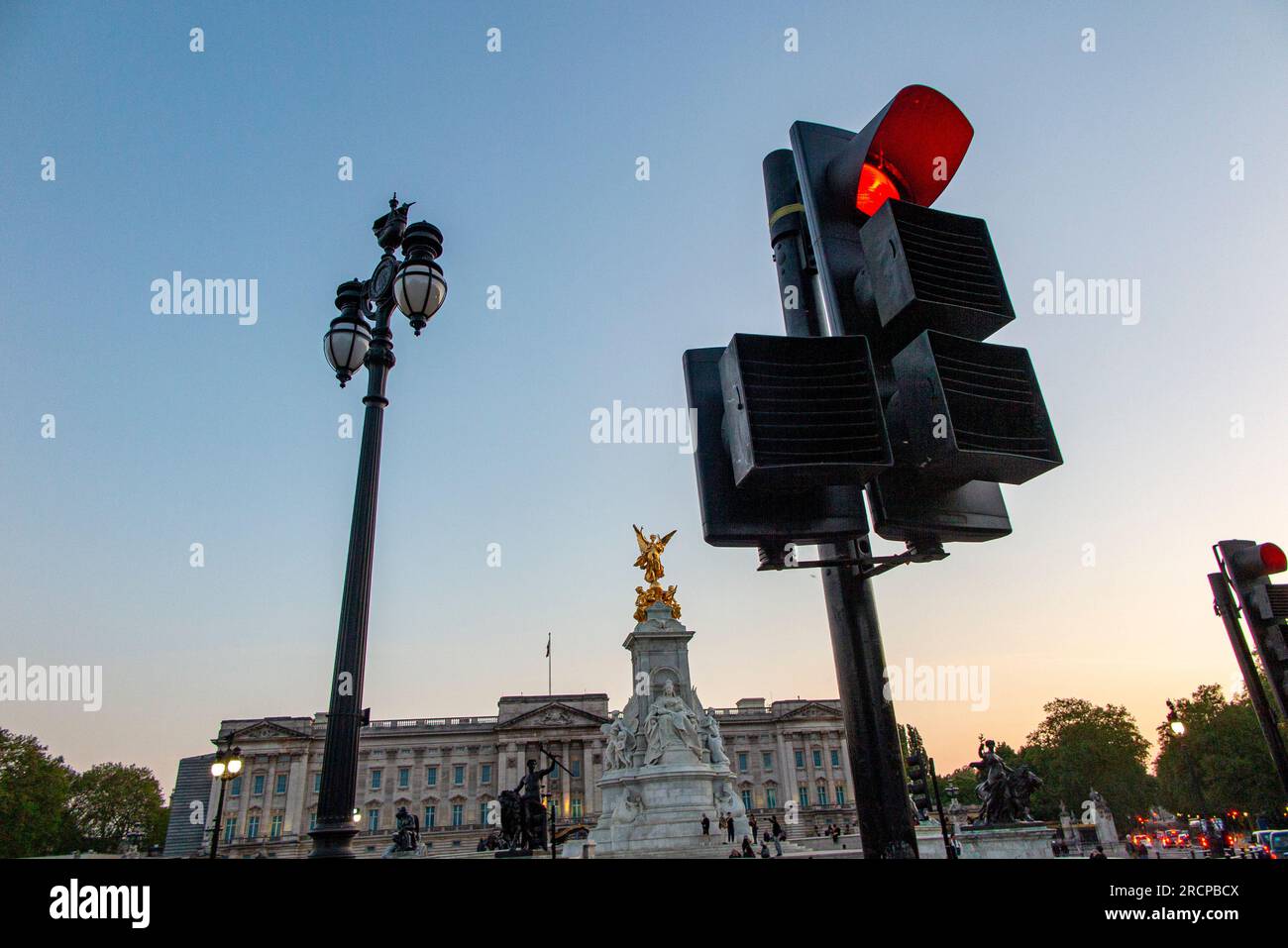 Traffic lights filter traffic on the Mall with Buckingham Palace in the ...