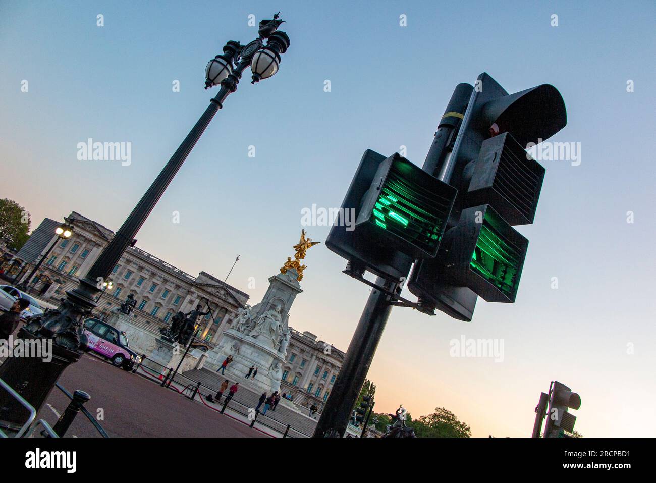 Traffic lights filter traffic on the Mall with Buckingham Palace in the ...