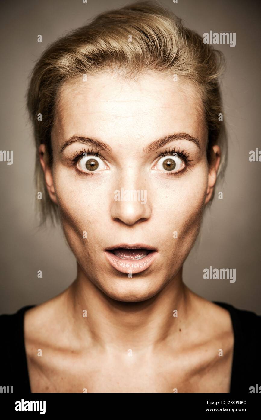 Surprised expression on the young woman's face Stock Photo - Alamy