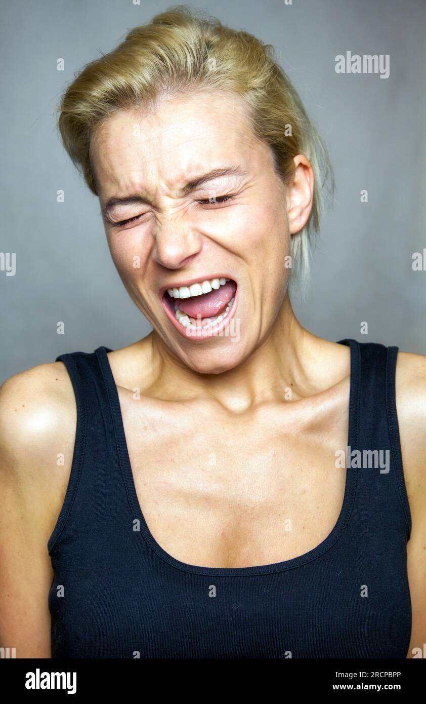 Screaming expression on the young woman's face Stock Photo - Alamy