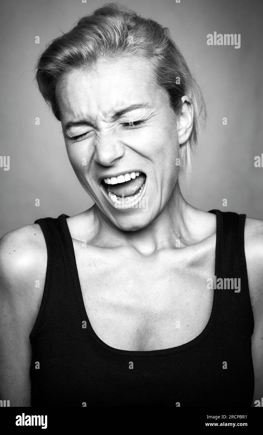 Screaming expression on the young woman's face Stock Photo - Alamy