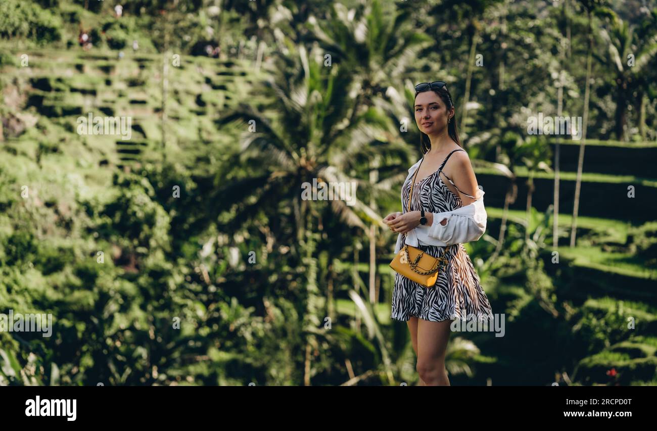 Close up shot of beautiful girl standing on rice terrace with green ...