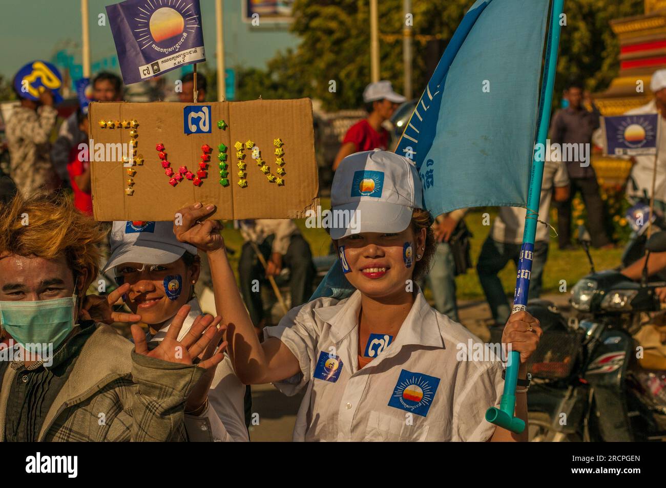 Female Sam Rainsy supporter holding a "#7 win" sign (Sam Rainsy is #7 ...