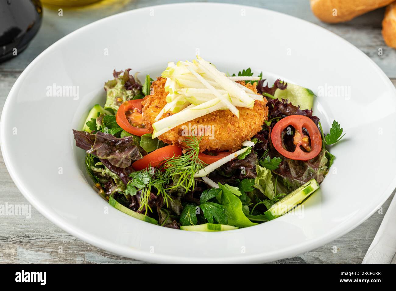 Deep fried goat cheese salad on a white porcelain plate Stock Photo - Alamy