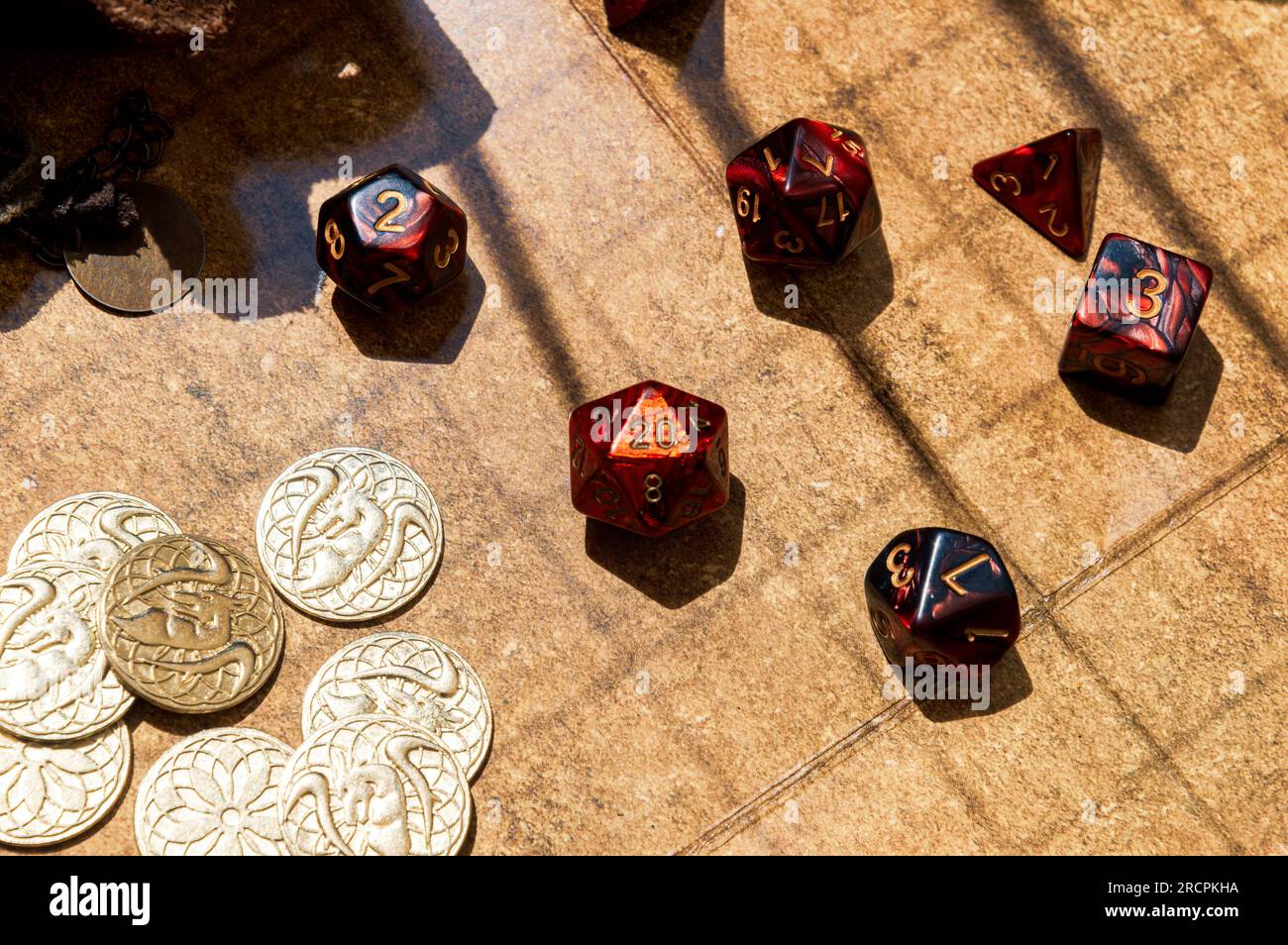 Overhead shot featuring a collection of vibrant red RPG dice and golden ...