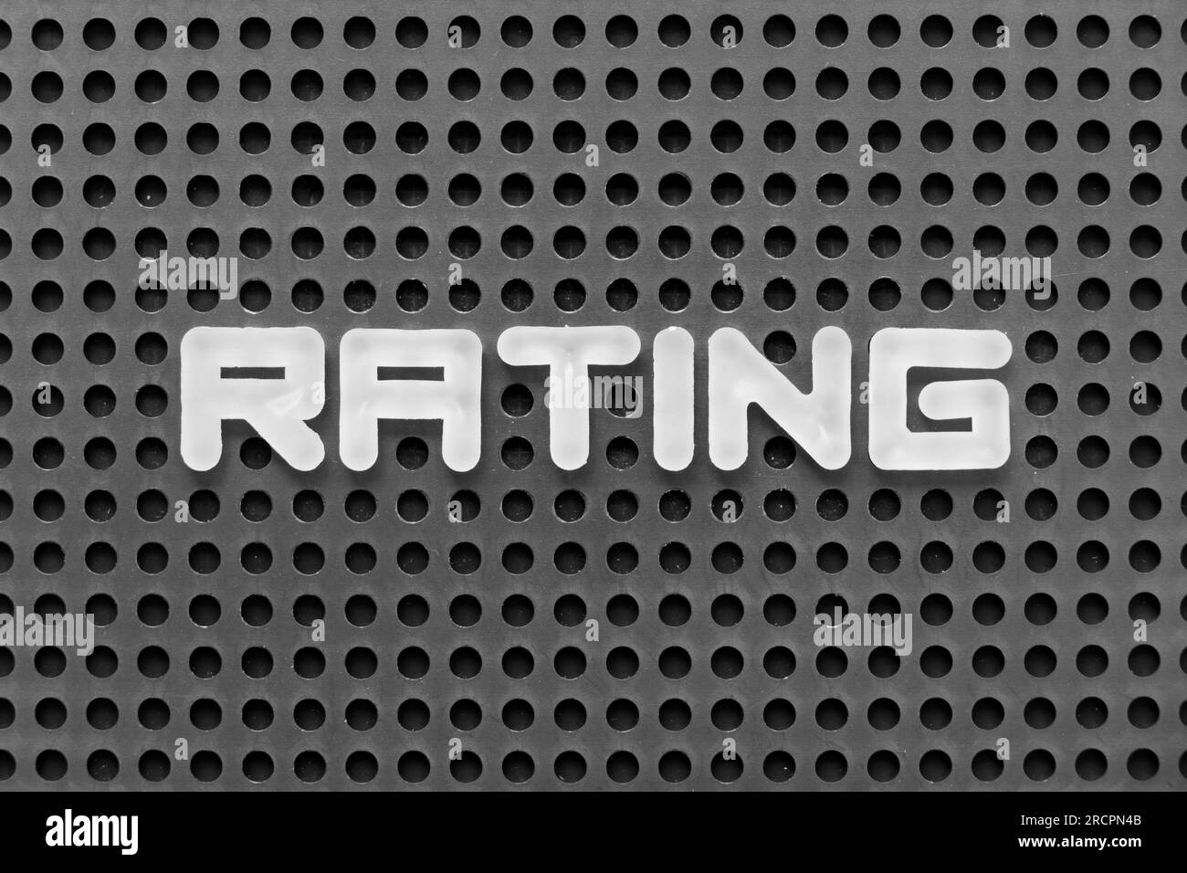 White alphabet letter in word rating on black pegboard background Stock ...