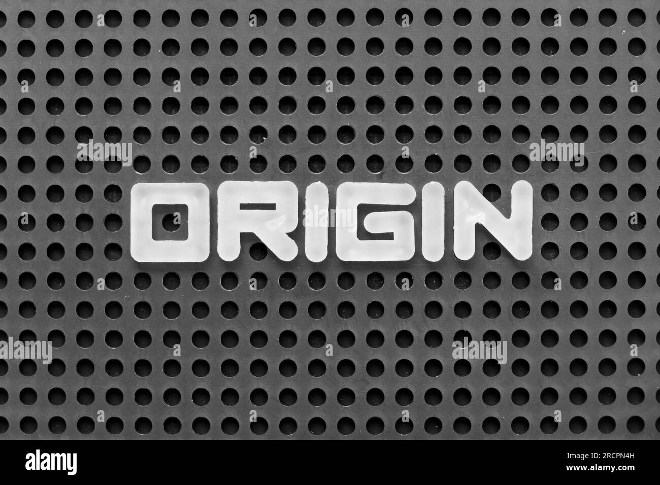 White alphabet letter in word origin on black pegboard background Stock ...