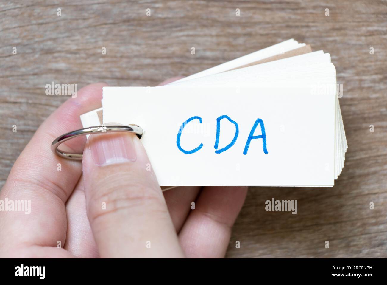 Hand hold flash card with handwriting in word CDA (Abbreviation of ...