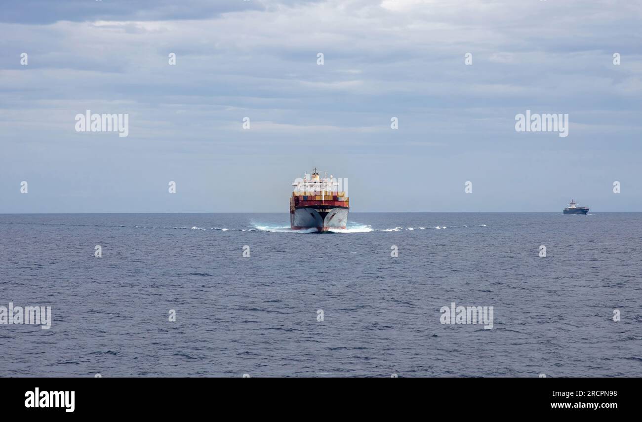 Container cargo ship full loaded in wavy sea reaches the port. Import ...