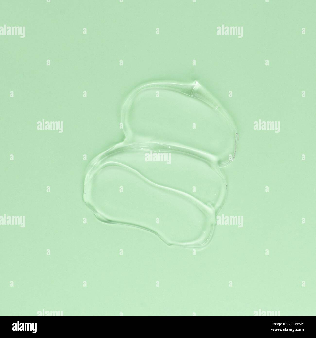 Smear of transparent cream for face and body on a green background ...