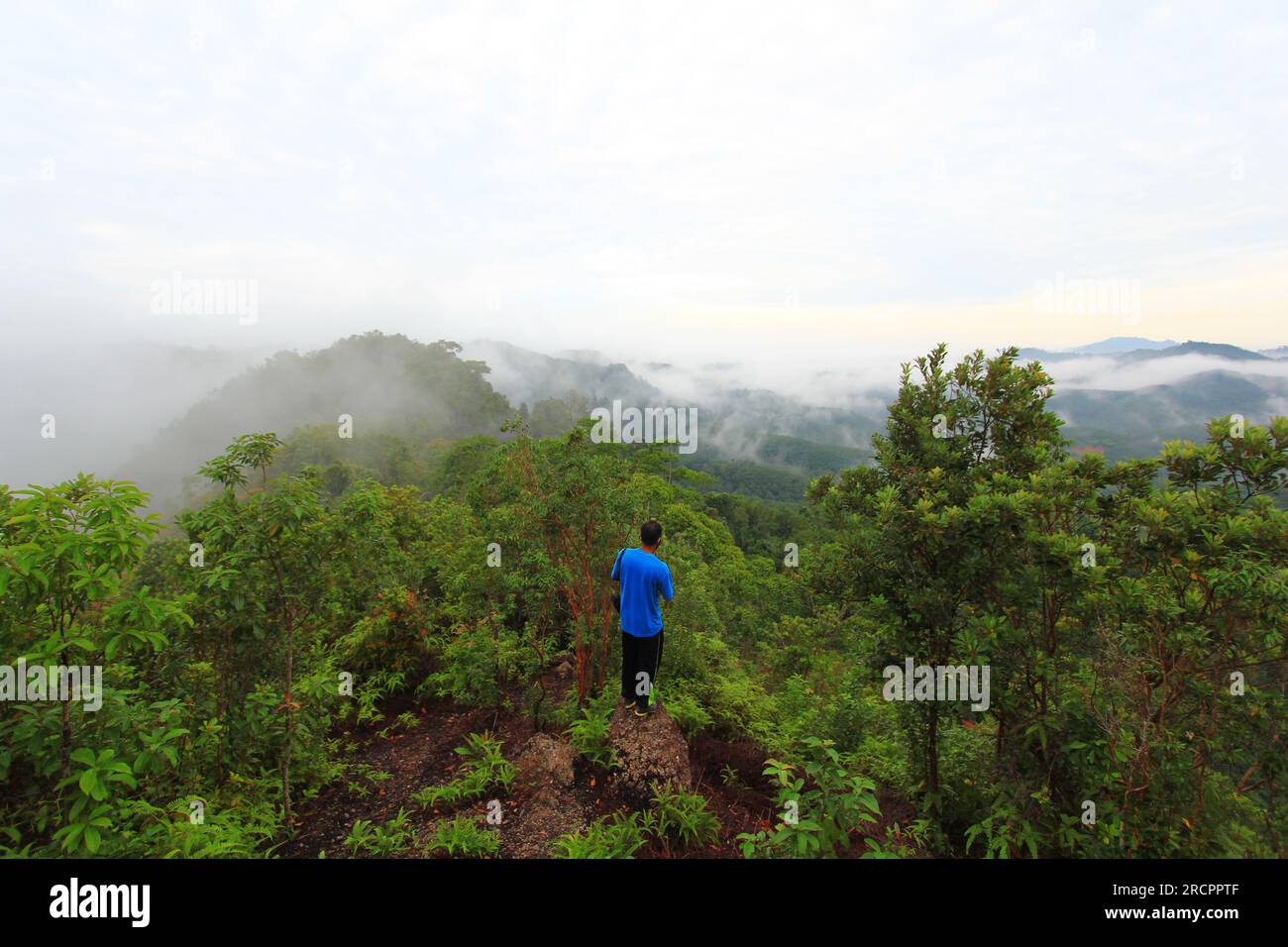 A man standing on the top of the mountain and looking at the mist Stock ...