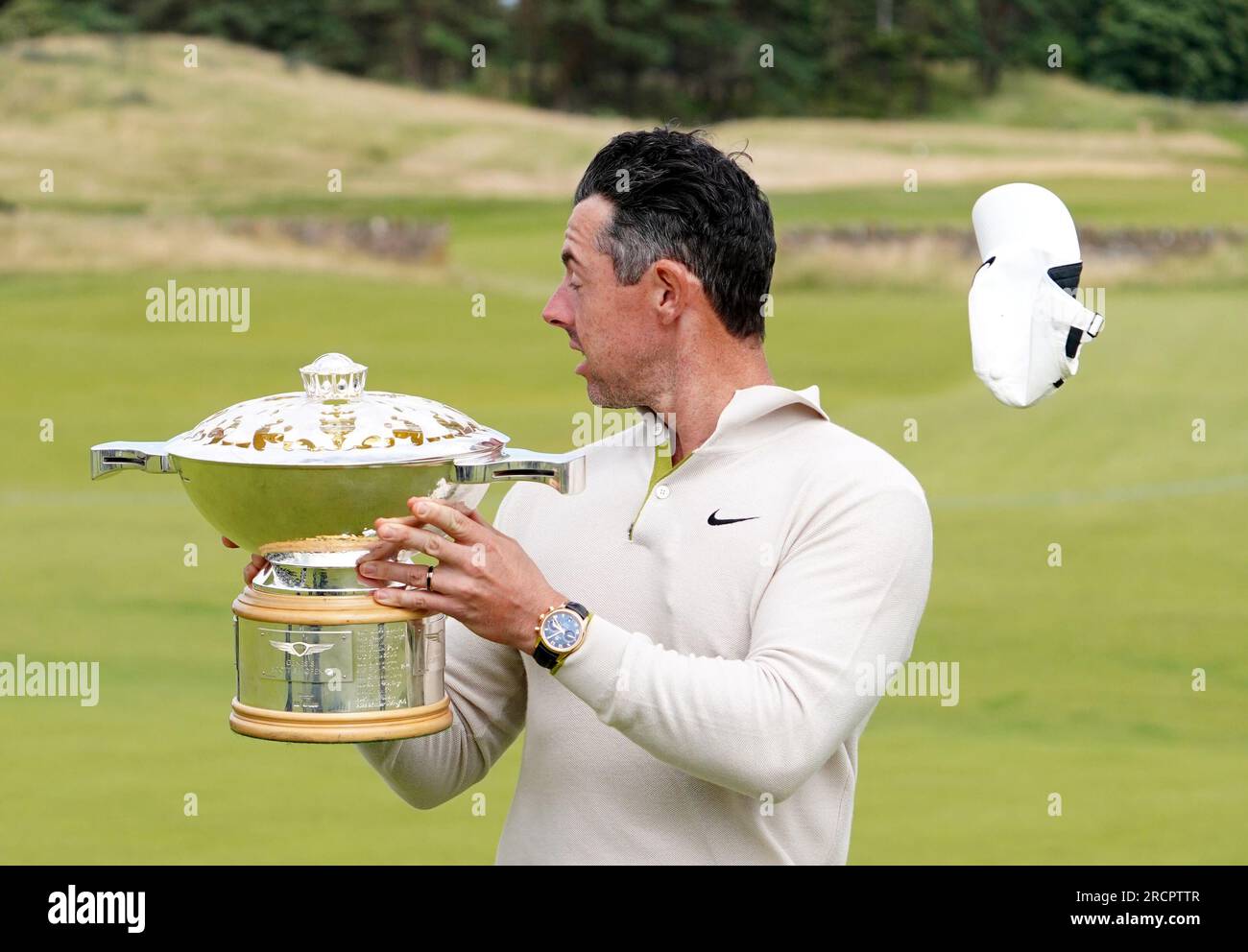 Rory McIlroy's hat blows off as he poses for photographs with the trophy following day four of ...