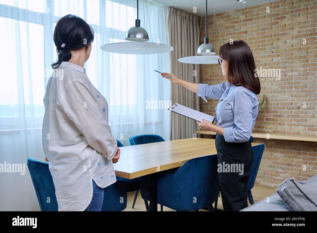 Female real estate agent showing apartment, house, to buyer, tenant ...