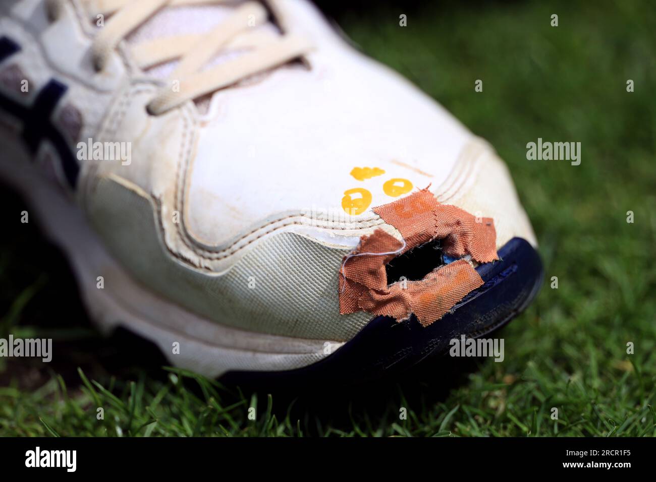 A detailed view of a hole cut into the toe area of a trainer of an ...