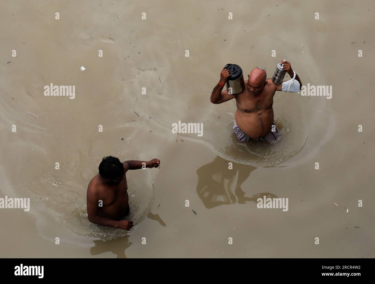 Locals wade through the waterlogged road despite slight decrease of the ...