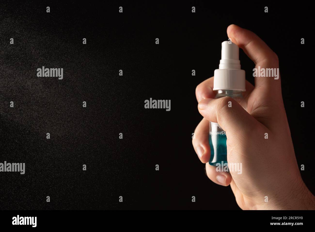 Spray liquid in hand close up view isolated on black background Stock ...