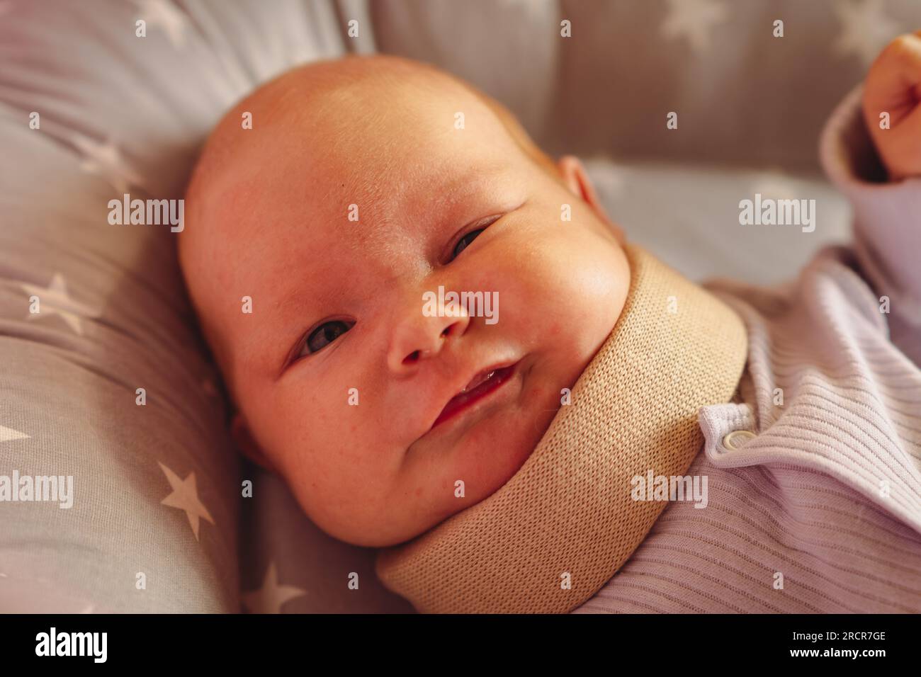 Cute newborn baby in a neck brace. Kid wearing cervical collar ...