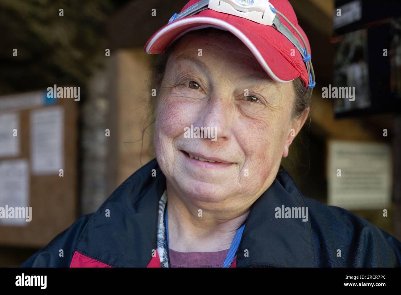 Large portrait of an adult female tour guide with a cap and headlamp at ...