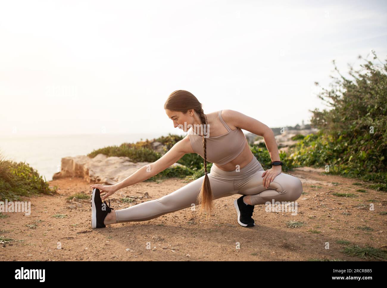Happy young european lady athlete in sportswear doing workout ...