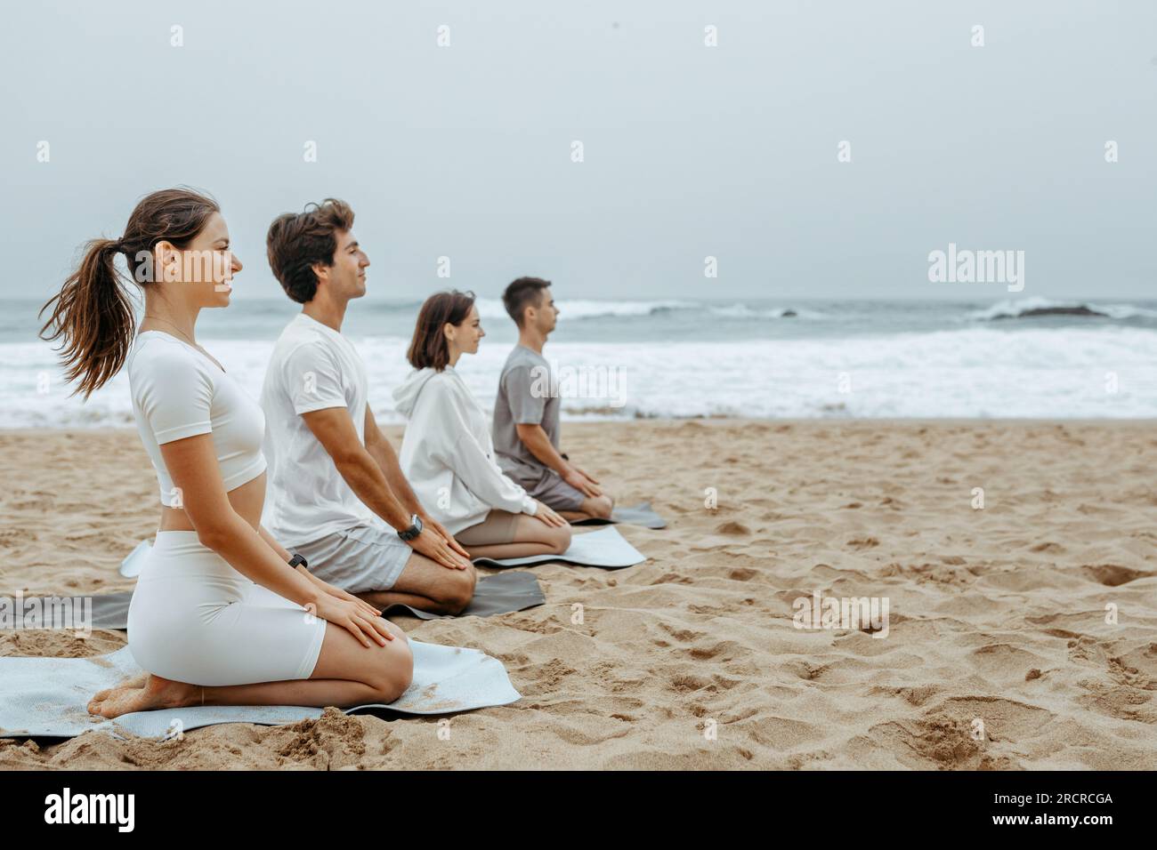 Unearthing inner peace. Young men and woman practicing yoga on the ...
