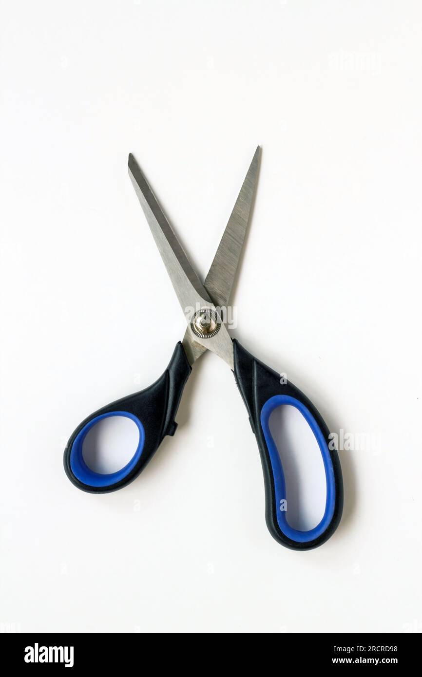 Metal scissors with blue plastic handle,on a white surface with copy ...
