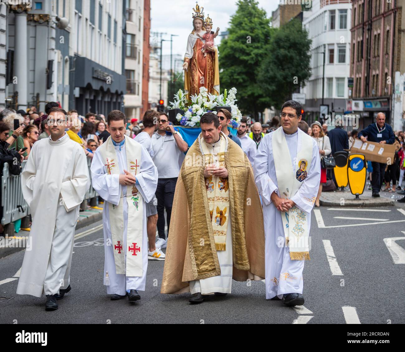 London, UK. 16 July 2023. Priests ahead of people carrying the statue ...