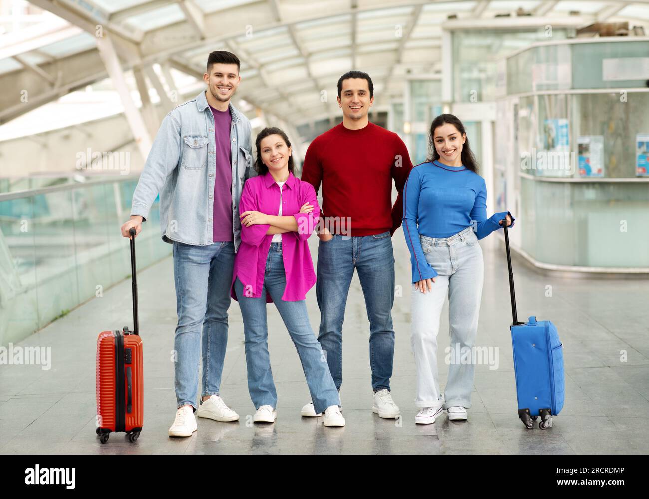 Two Happy Couples Friends Posing With Luggage Standing In Airport Stock ...