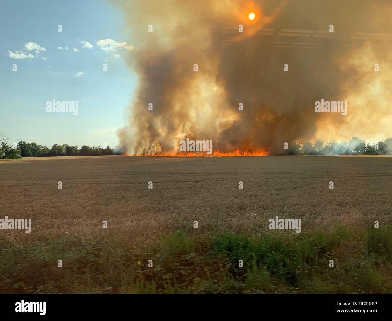 16 July 2023, Saxony, Leipzig: A grain field is burning north of ...