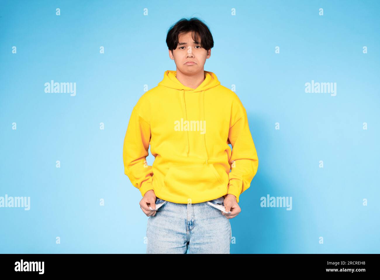 Upset Asian Young Teen Guy Showing Empty Pockets, Blue Background Stock ...