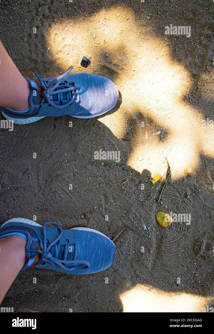 Top Down View Of Woman's Legs In Gray Sneakers On Country Road. Concept ...