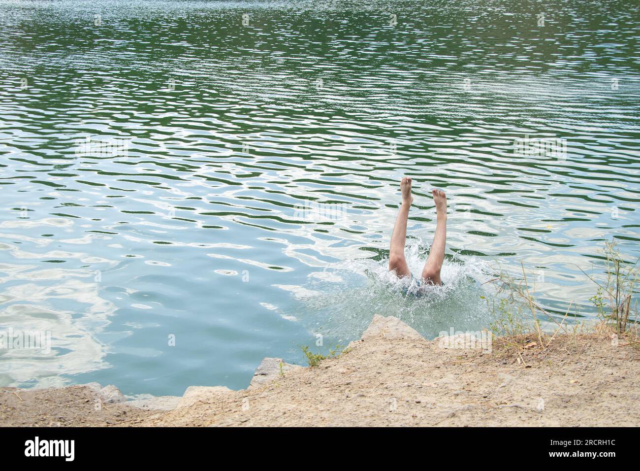 Men's legs stick out of the water in a quarry in Ukraine during ...