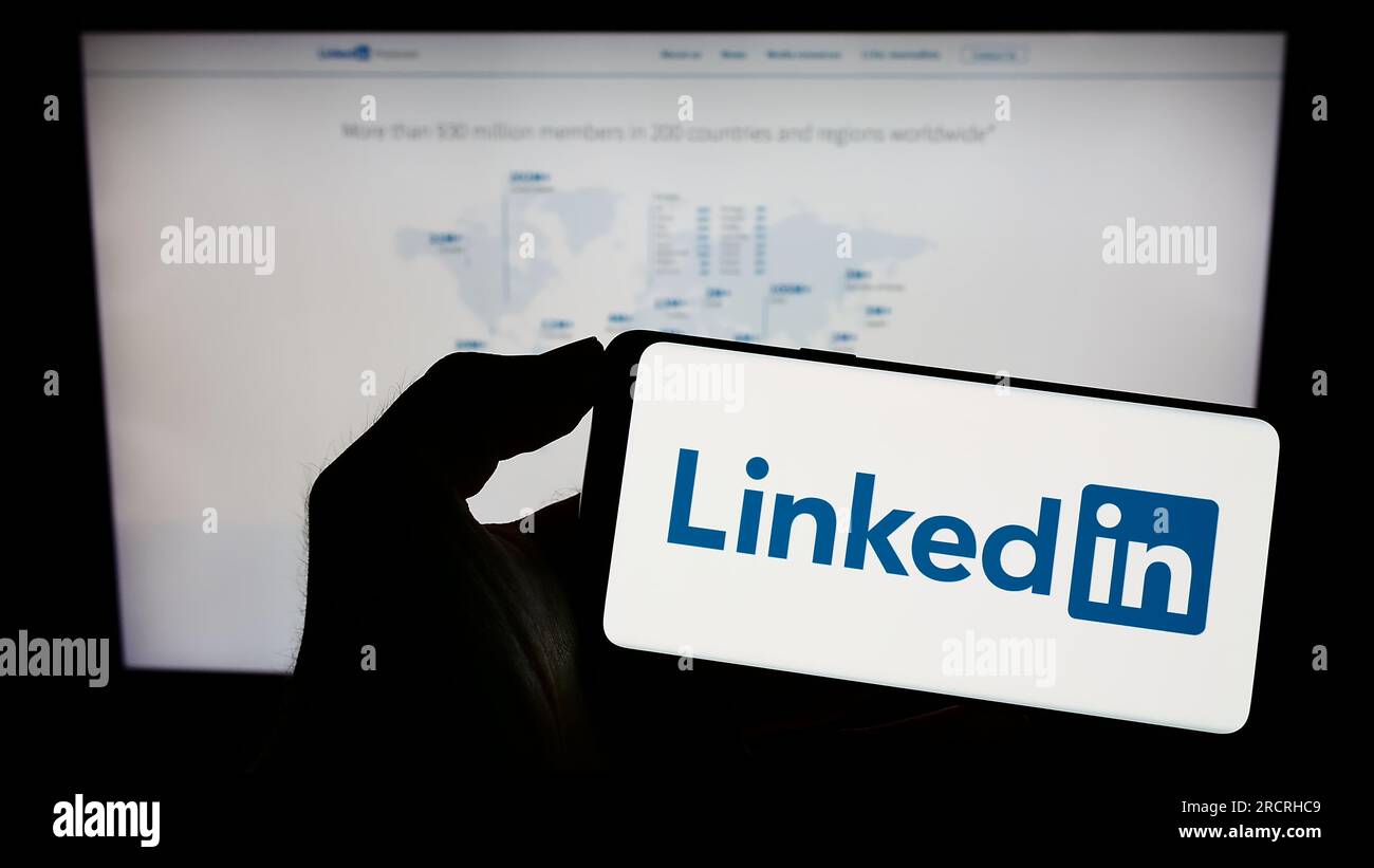 Person holding mobile phone with logo of US social media company ...