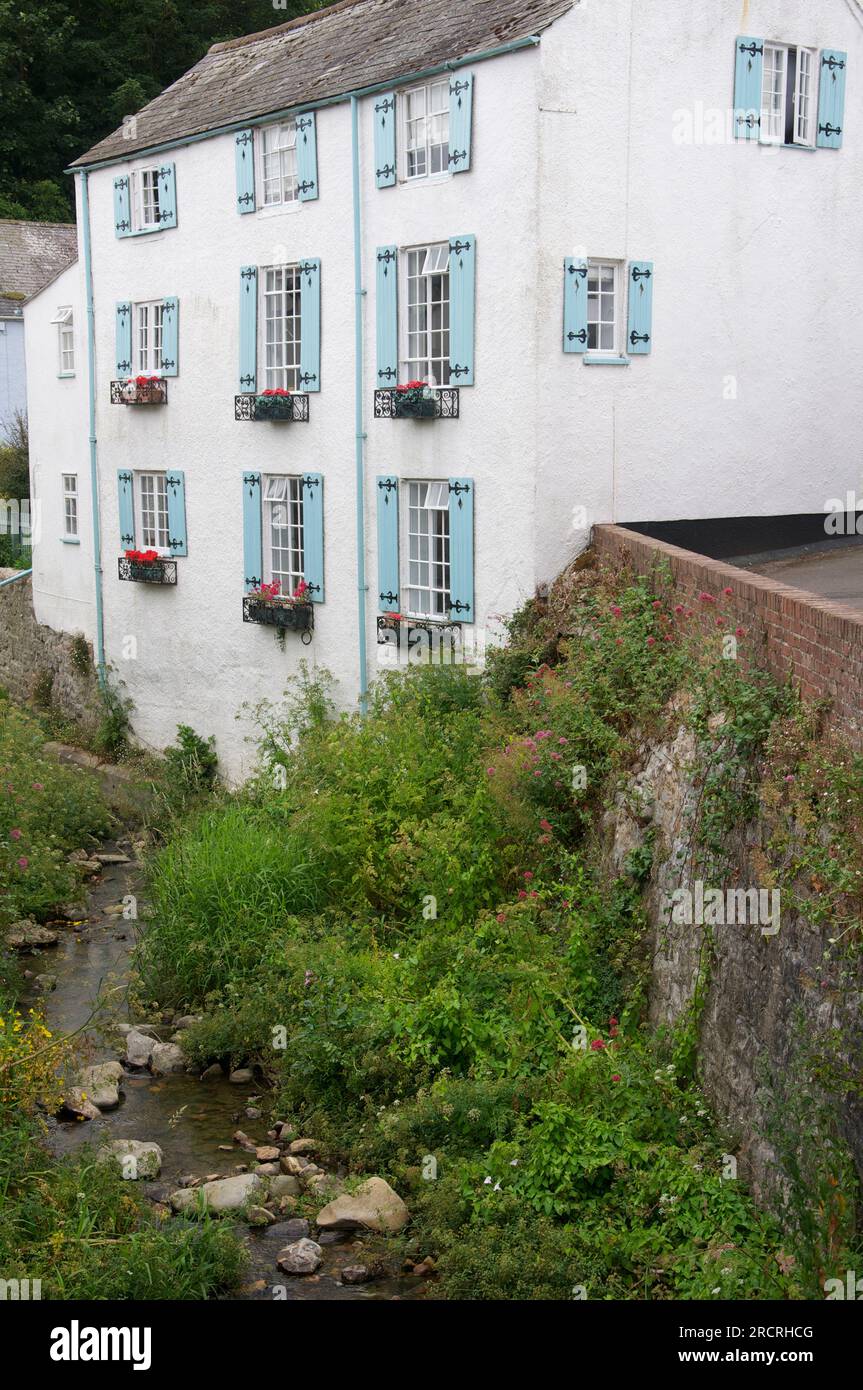 A white house with shuttered windows perches above the river Lim ...
