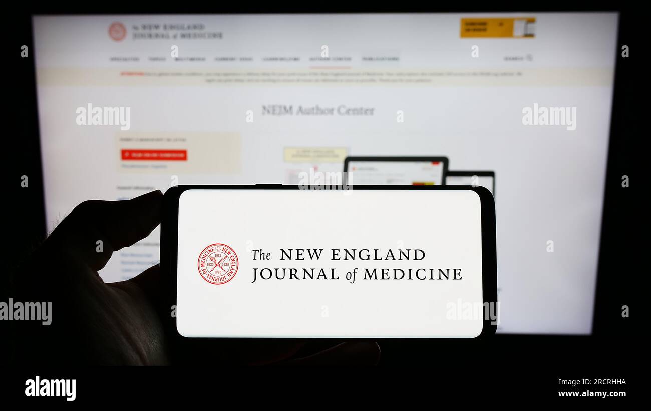 Person holding mobile phone with logo of The New England Journal of ...