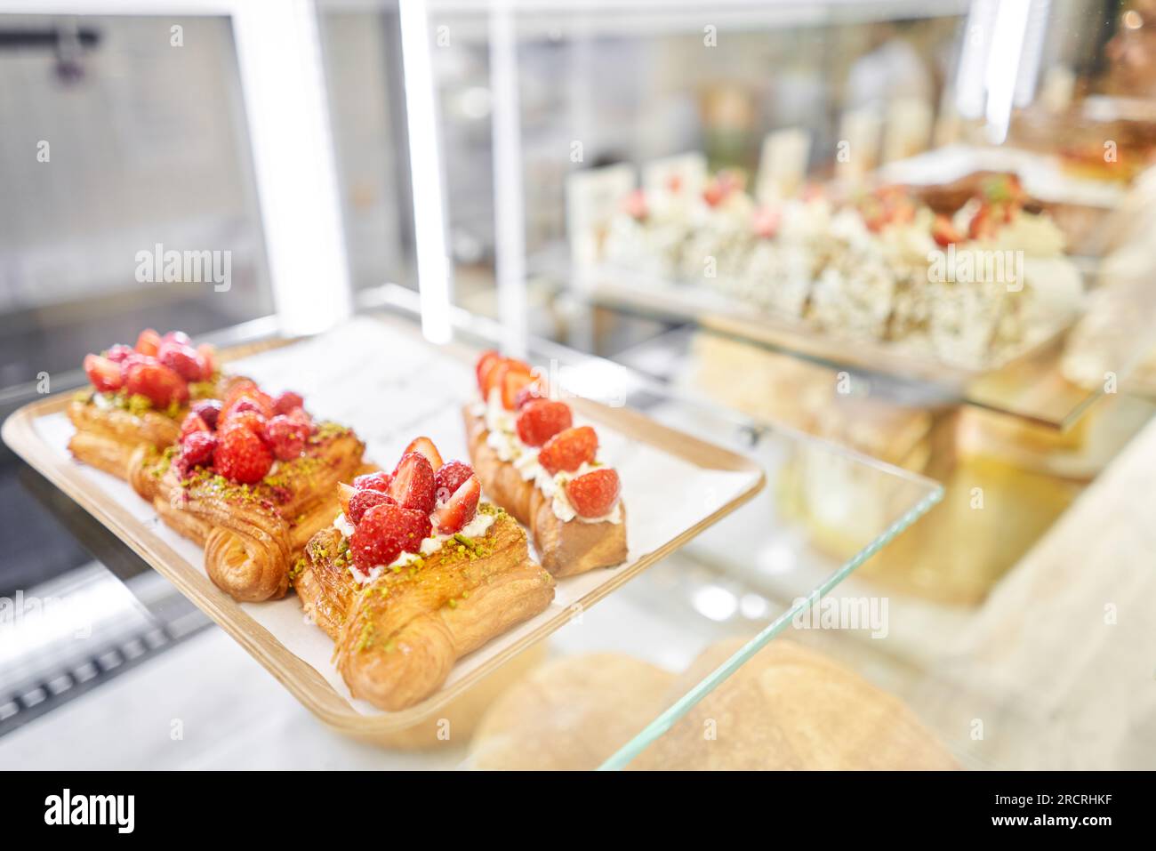 A variety of fresh pastries in the bakery window. almond croissant is ...