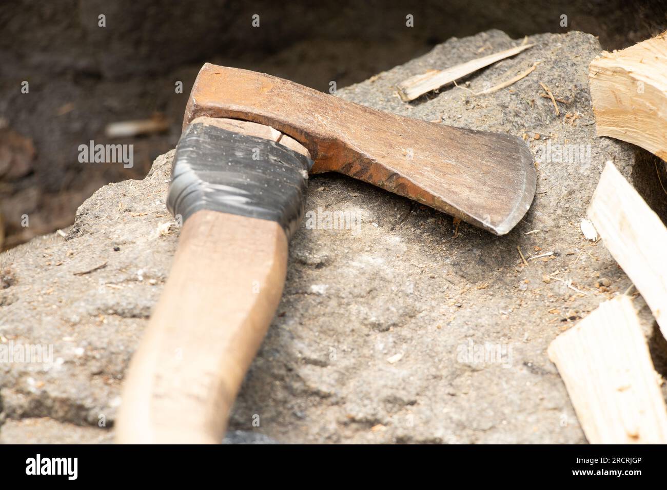 An old working ax lies on a granite stone in the summer in the forest ...