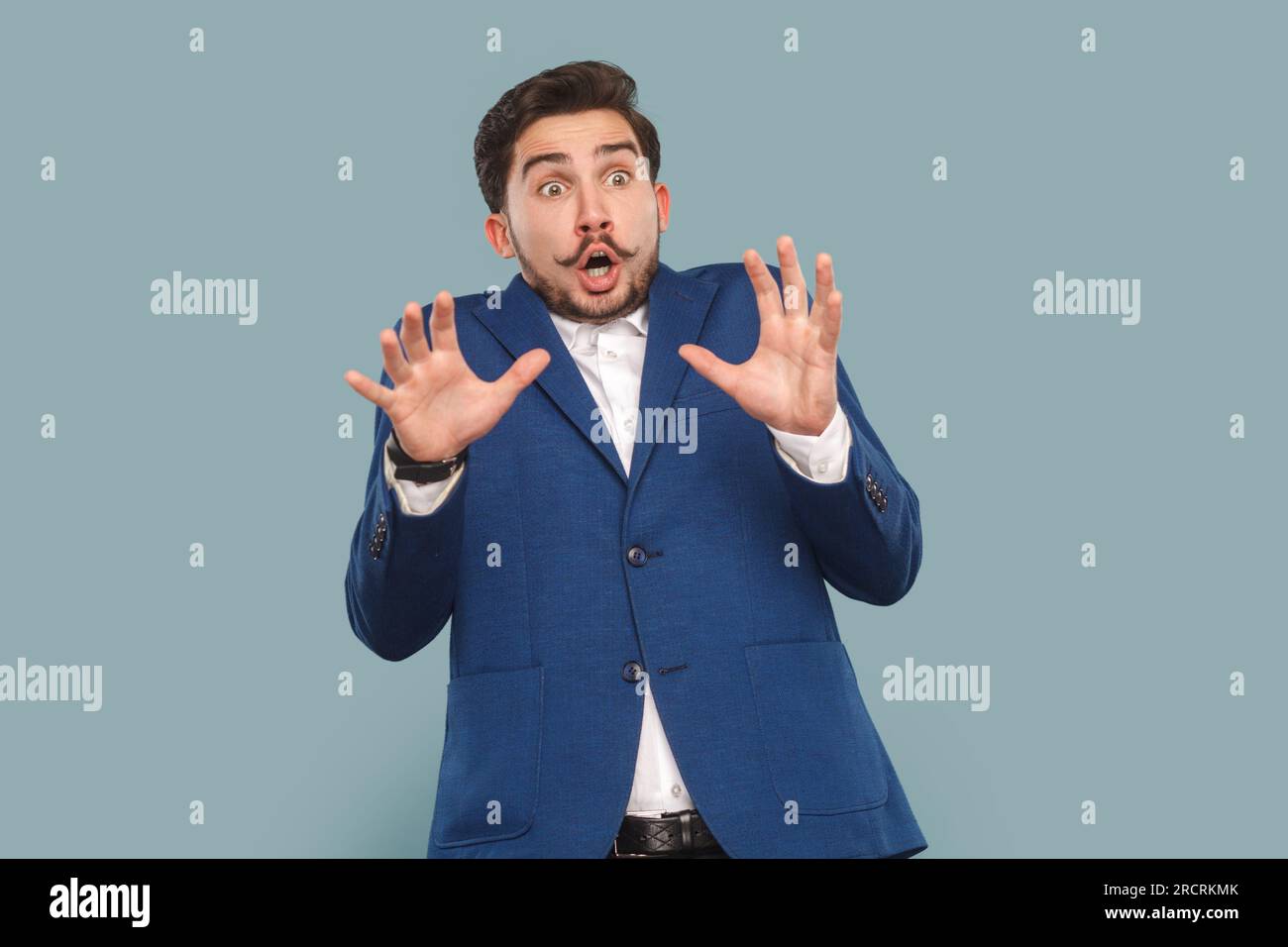 Portrait of frighten shocked man with mustache standing with raised ...