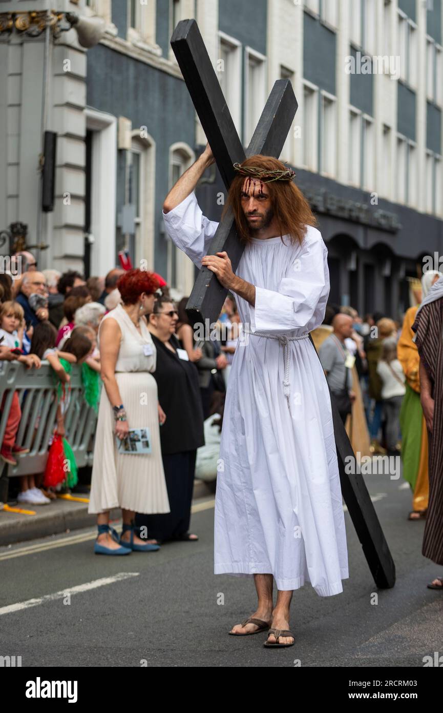London, UK. 16 July 2023. A man playing Jesus carrying the cross ...