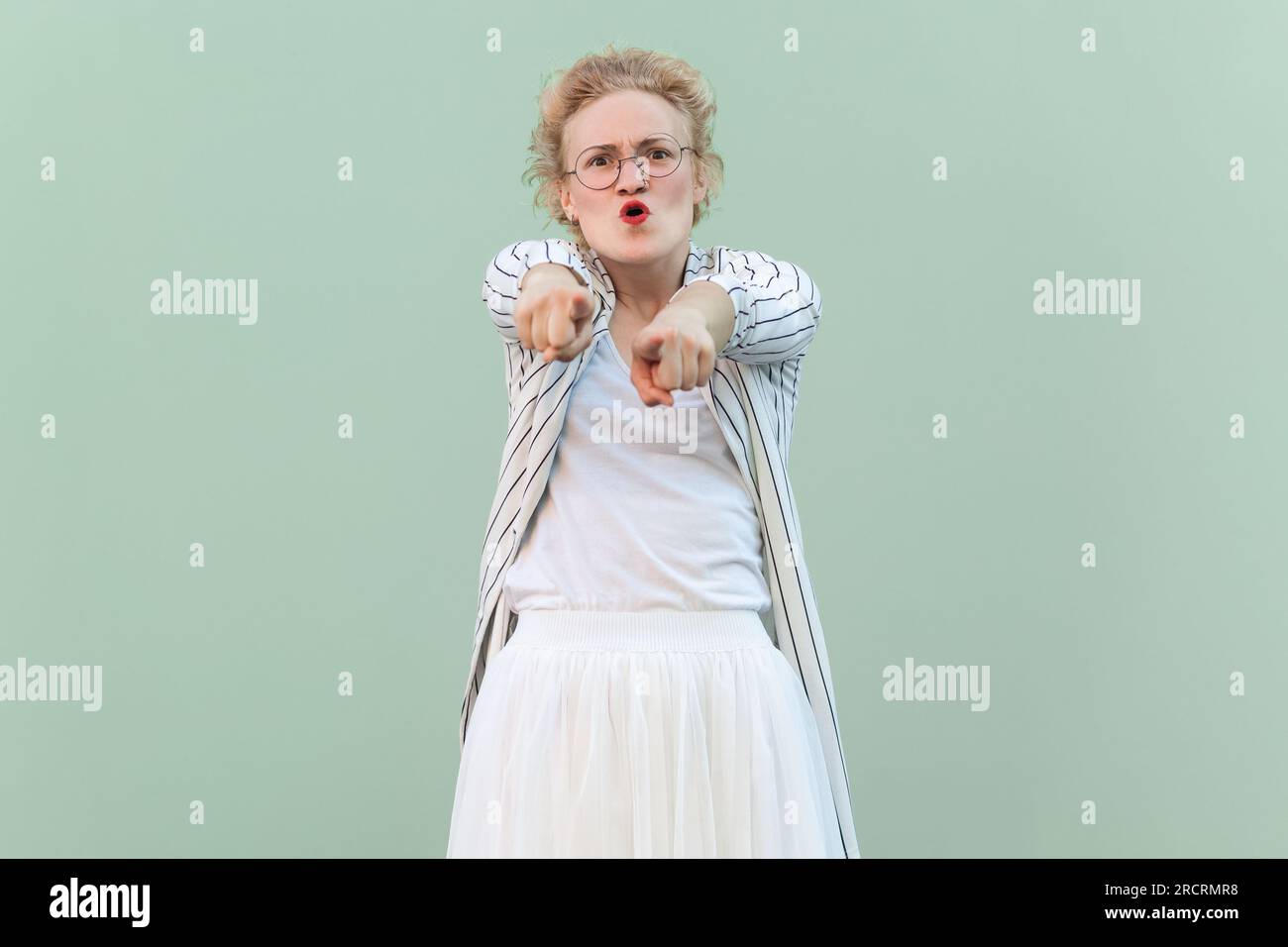 Portrait of angry shocked young adult blonde woman wearing striped ...